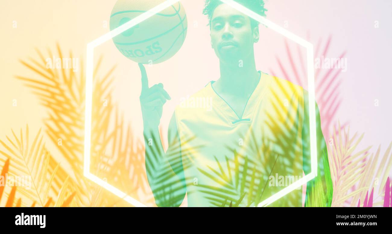 Composite of illuminated plants and hexagon over biracial male player ...