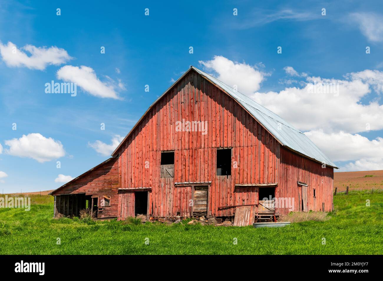Rural American scene of weathered red barn in Palouse Hills, Washington ...