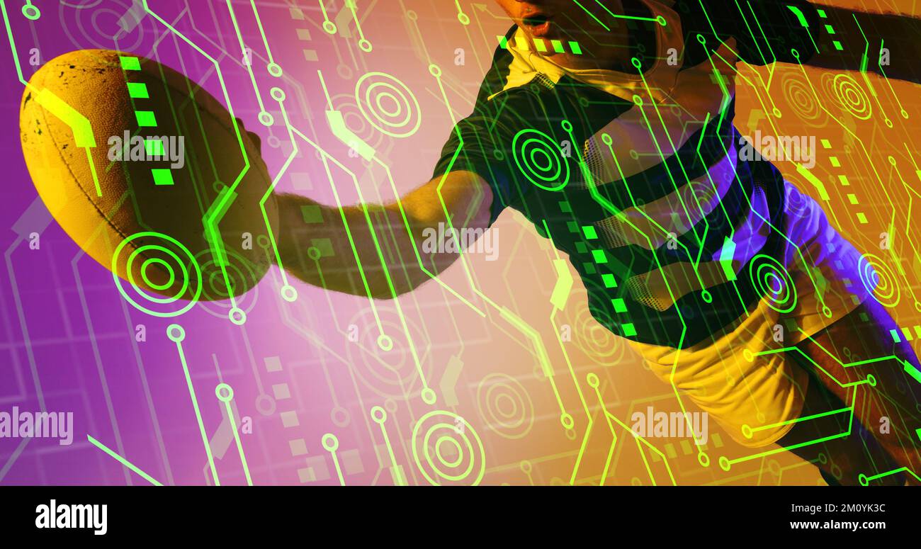 Midsection of caucasian rugby player catching ball over illuminated ...