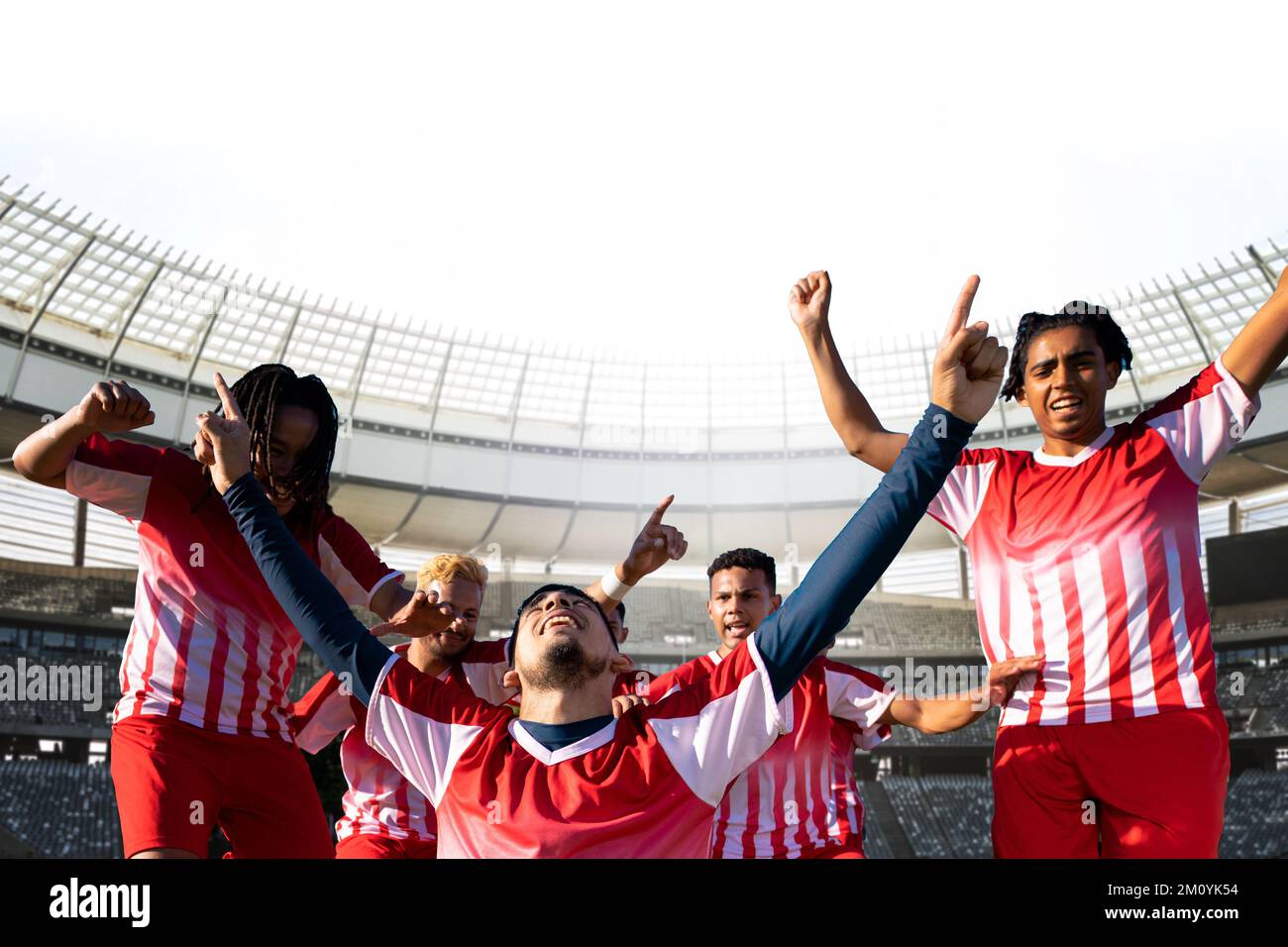 Team of multiracial young soccer players celebrating victory in stadium ...