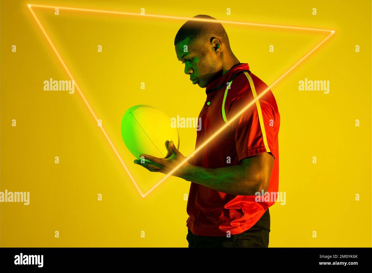 Triangle neon over african american young rugby player holding ball ...