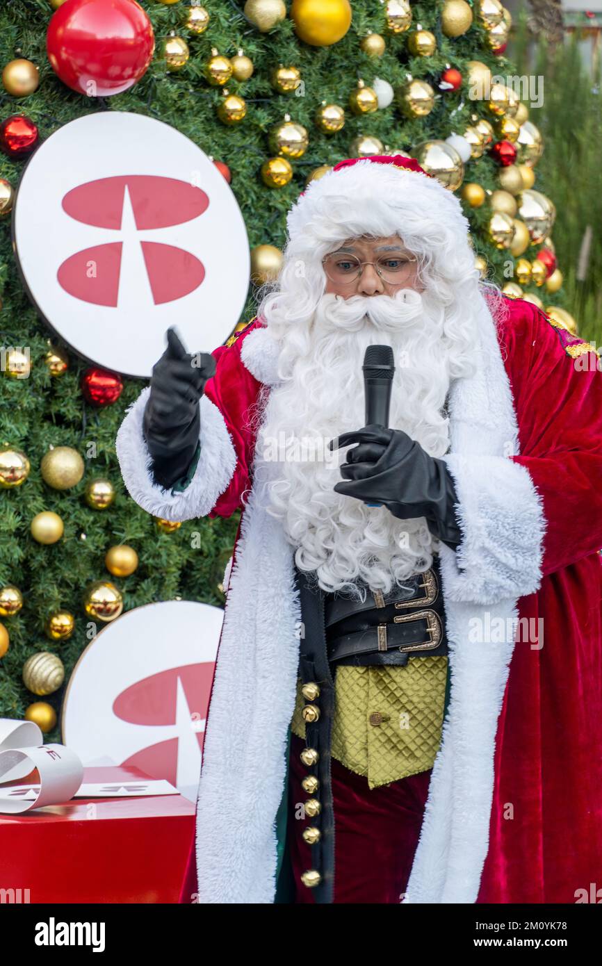 santa claus talking about christmas, behind a christmas tree in the ...