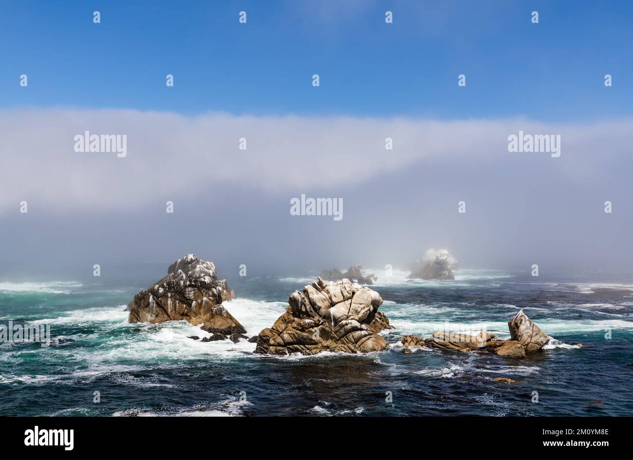 Rock formations in the ocean under a fog bank at Point Lobos State ...