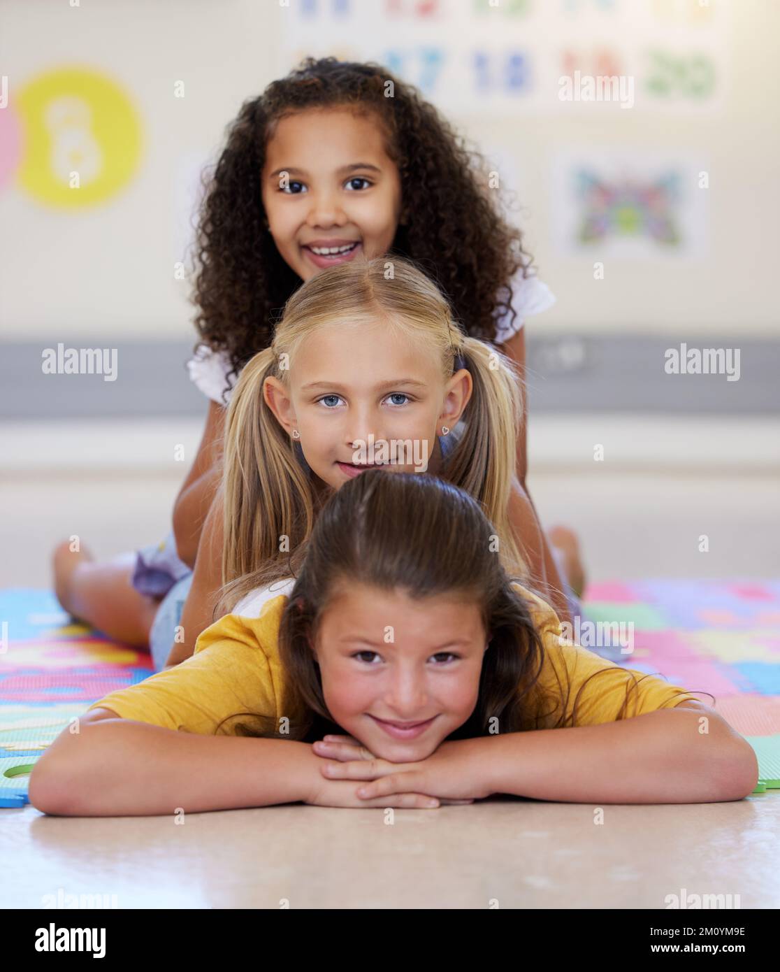 Growing and learning together. a group of kids laying on the floor in ...