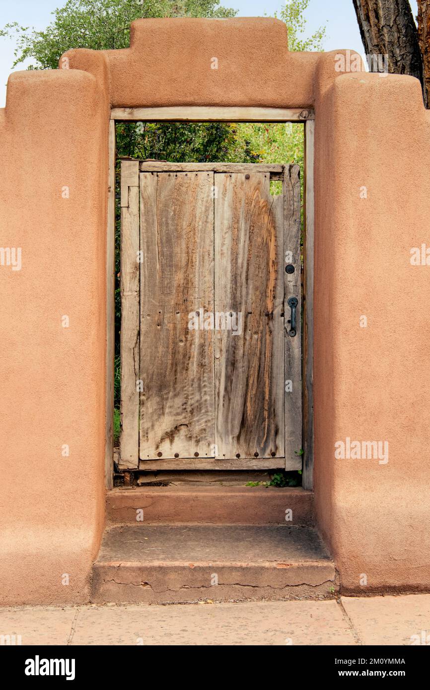 Weathered wood gate to garden in adobe wall in Santa Fe, New Mexico ...