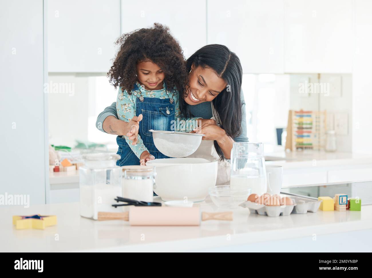 Helping mommy in the kitchen. an attractive young woman and her ...