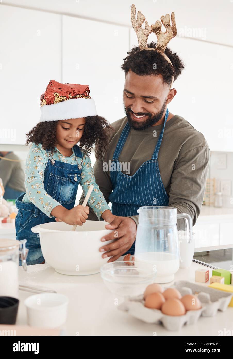Christmas treats. a handsome young man and his daughter baking in the ...