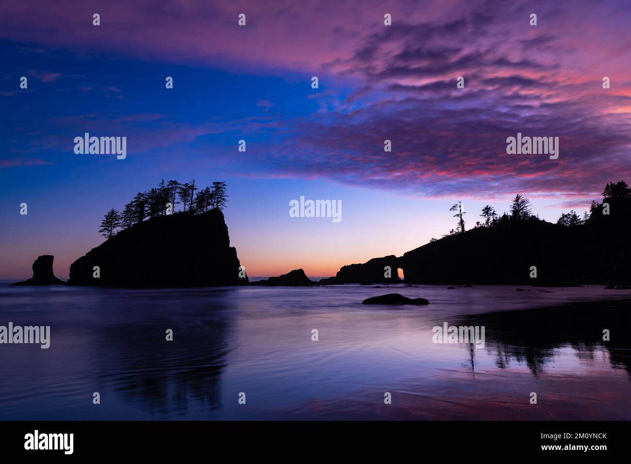 Long exposure of a spectacular sunset over a beach with silhouetted ...