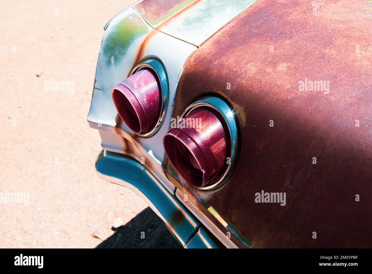 Vintage scene of red taillights on a rusty American car with a chrome ...
