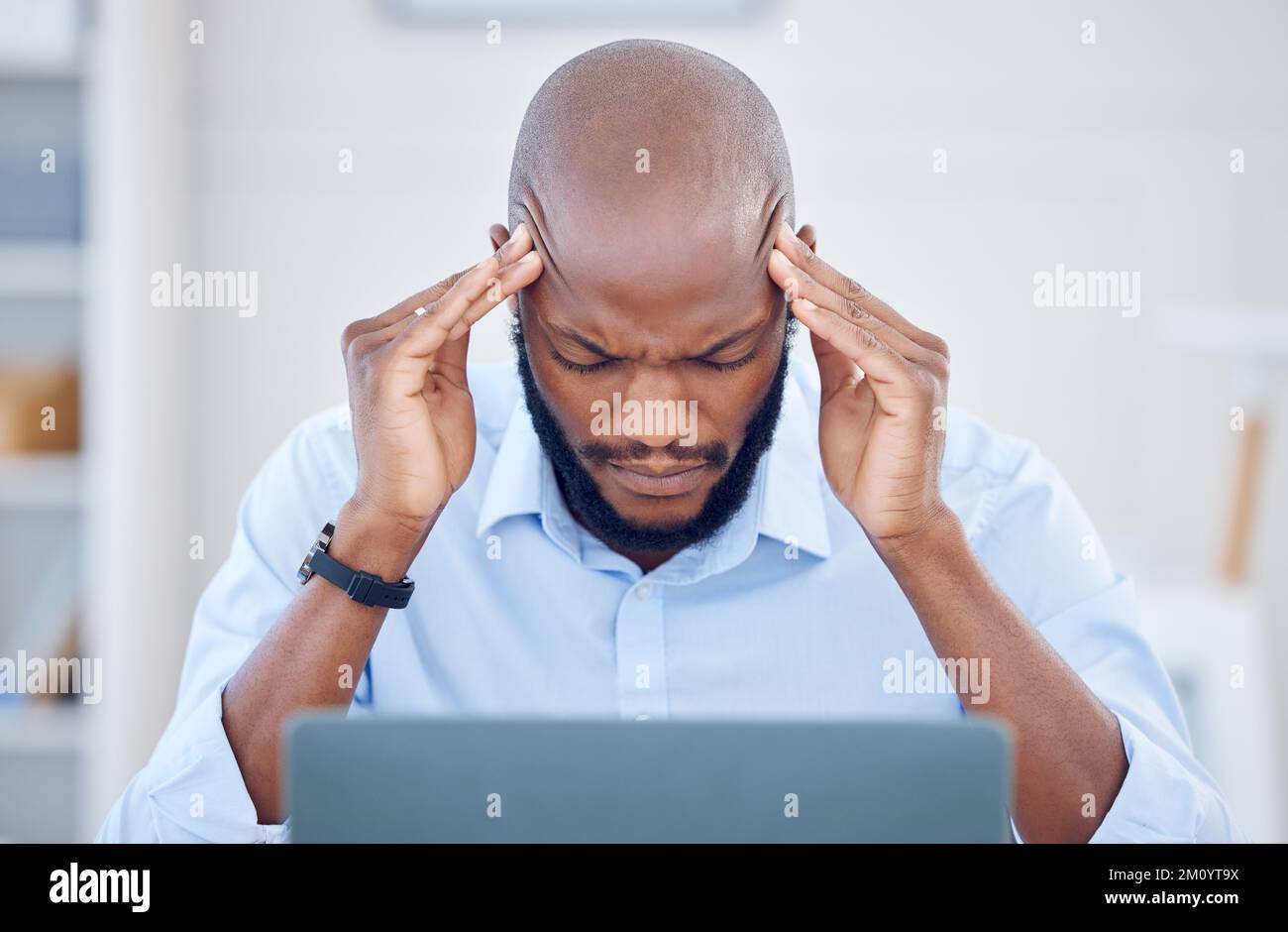 Its just so overwhelming. a young businessman suffering from a headache ...