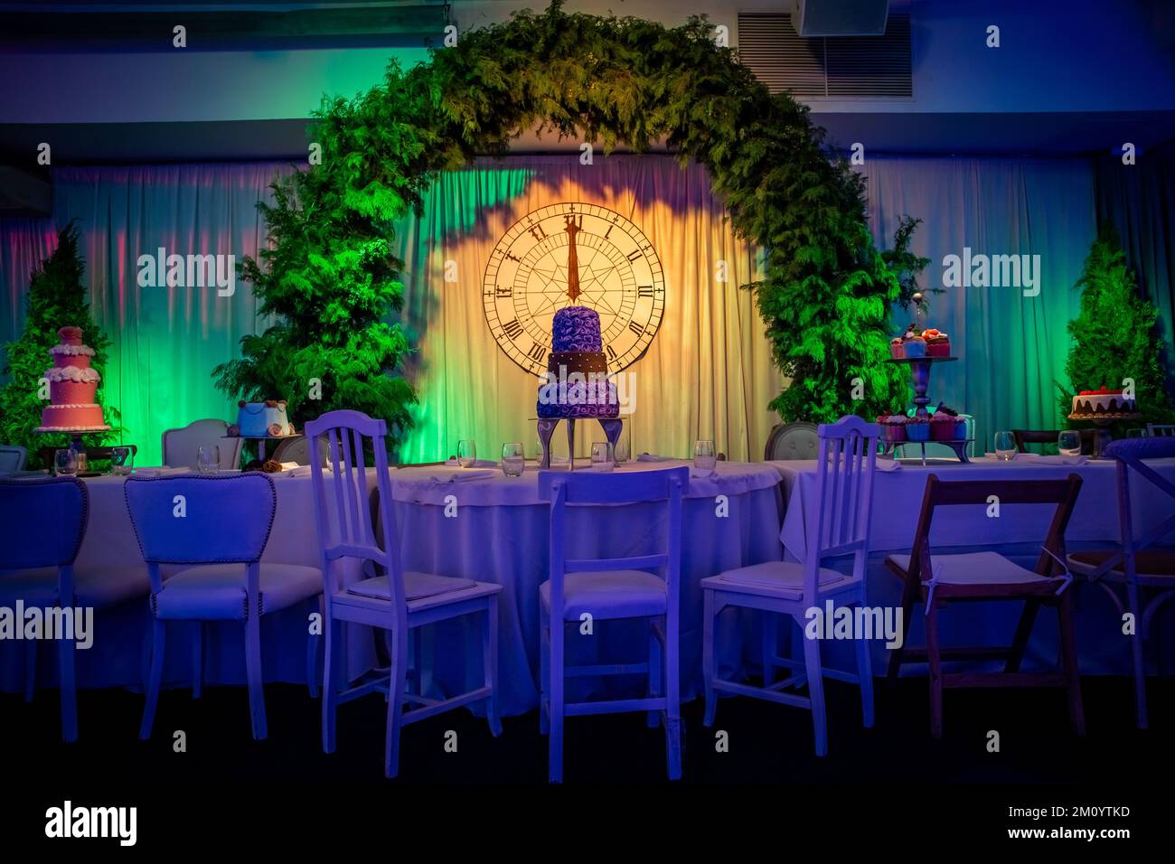 A beautifully decorated dessert banquet table with dishes illuminated ...