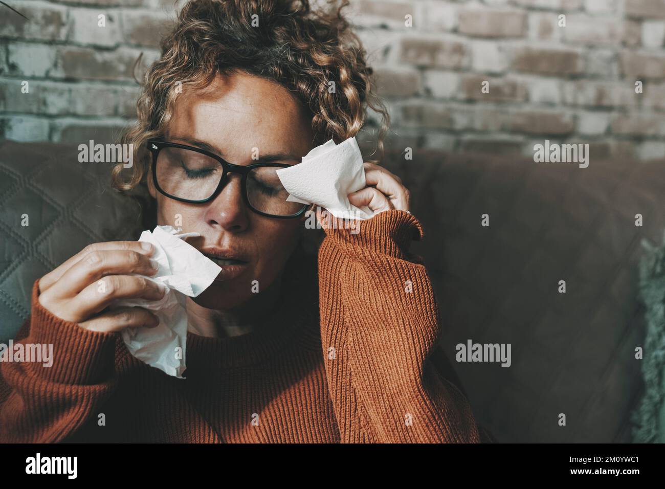 Portrait of woman in bad health condition using tissues and touching ...