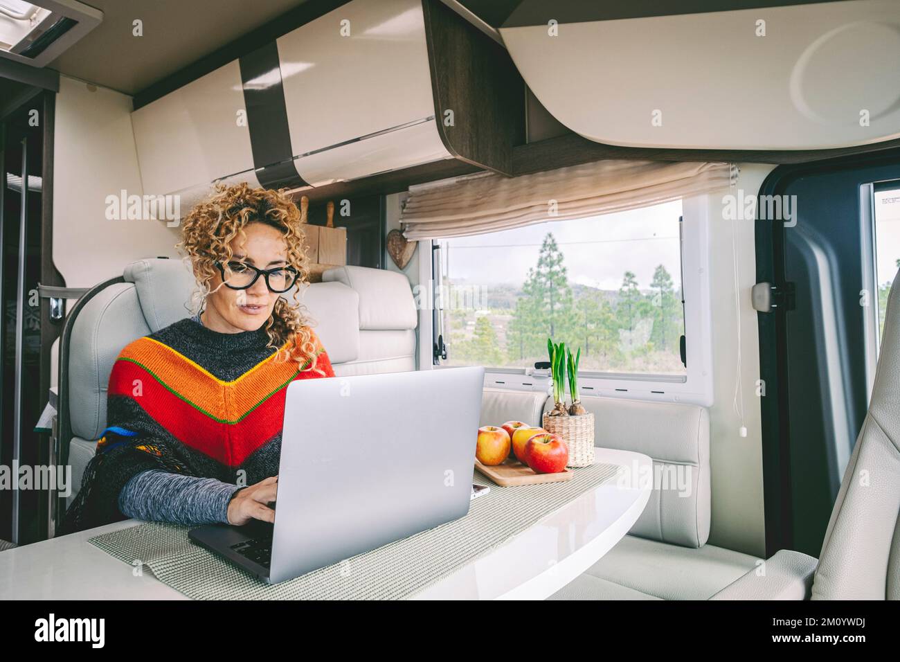 Independent woman sitting inside a camper van in smart remote working ...