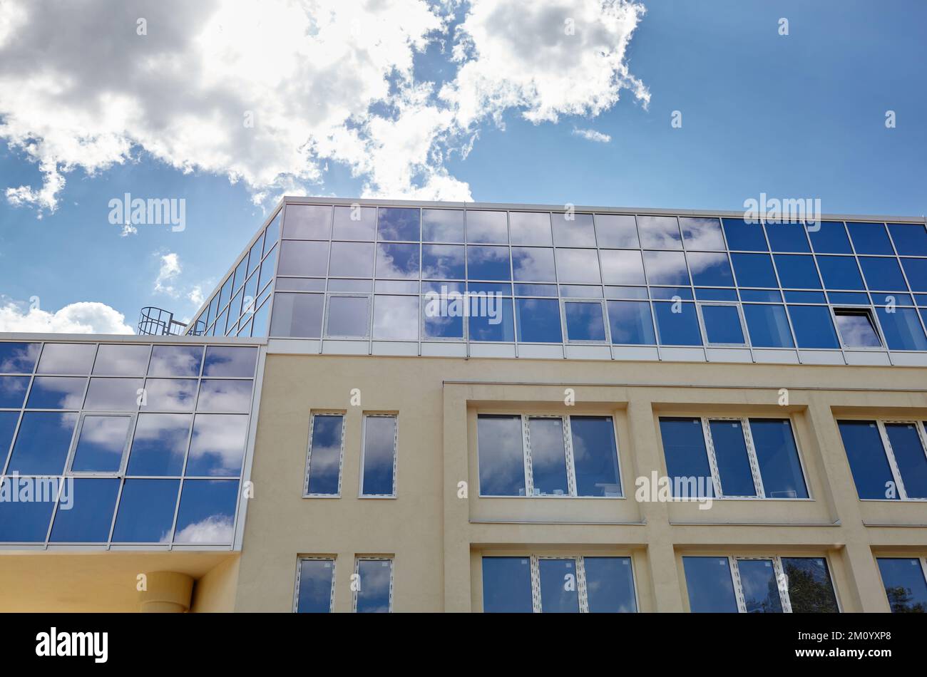 Clouds reflected in windows of modern office building. Exterior of ...
