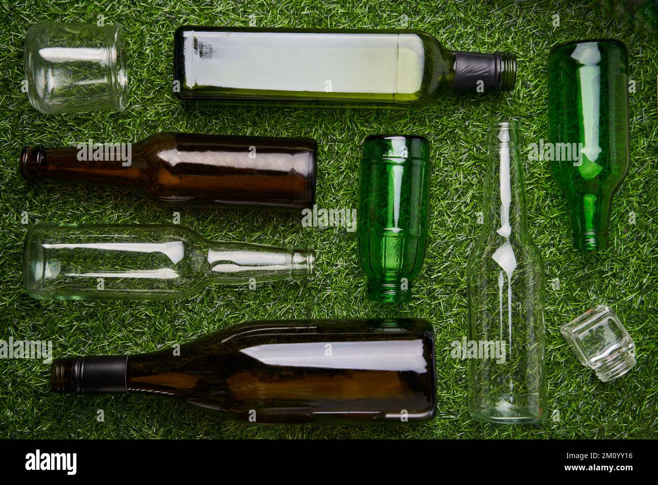 Separate collection of glass garbage. Recyclable glass waste on green ...