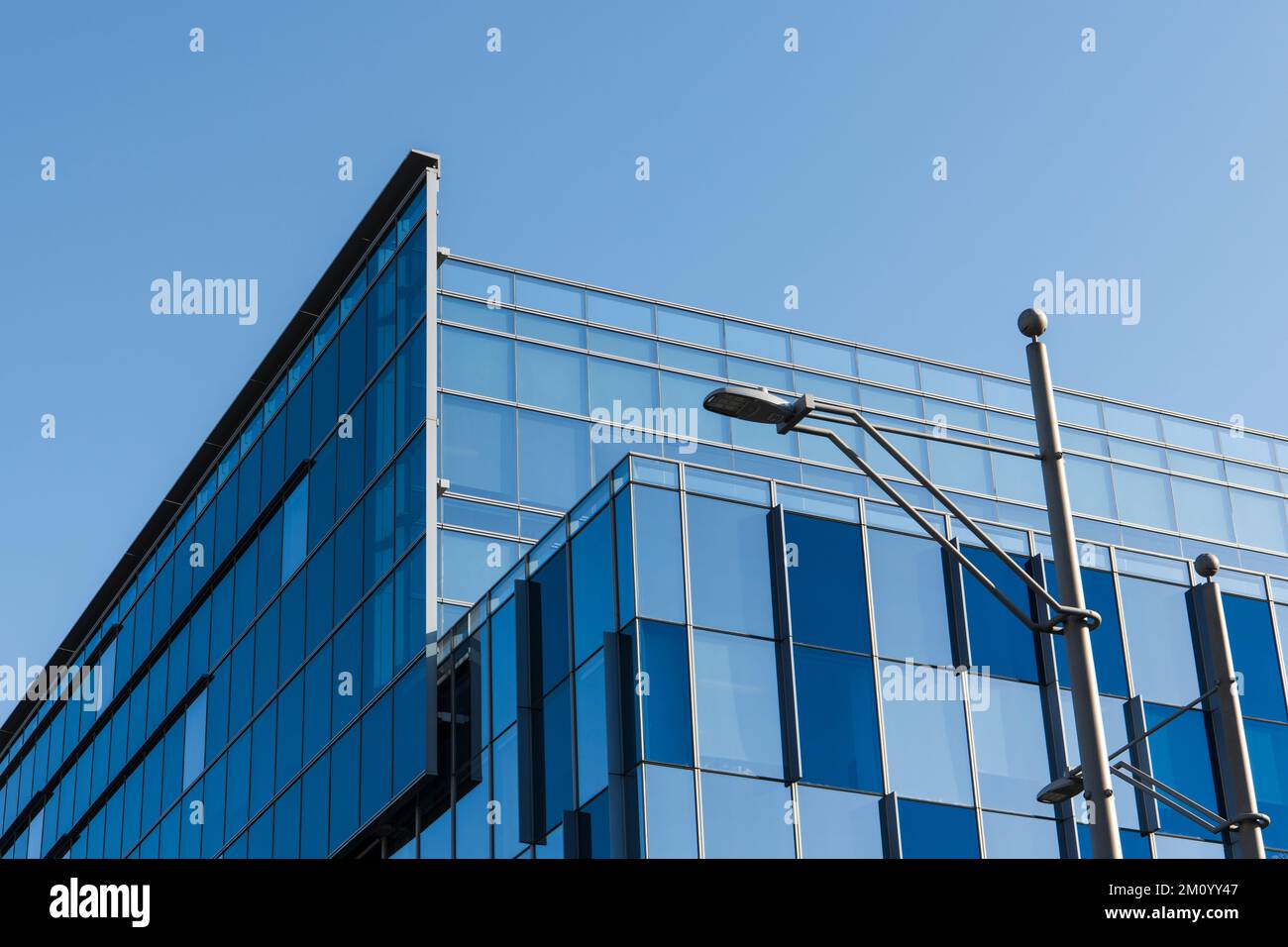 Angled view of a modern glass and steel building with a blue color ...