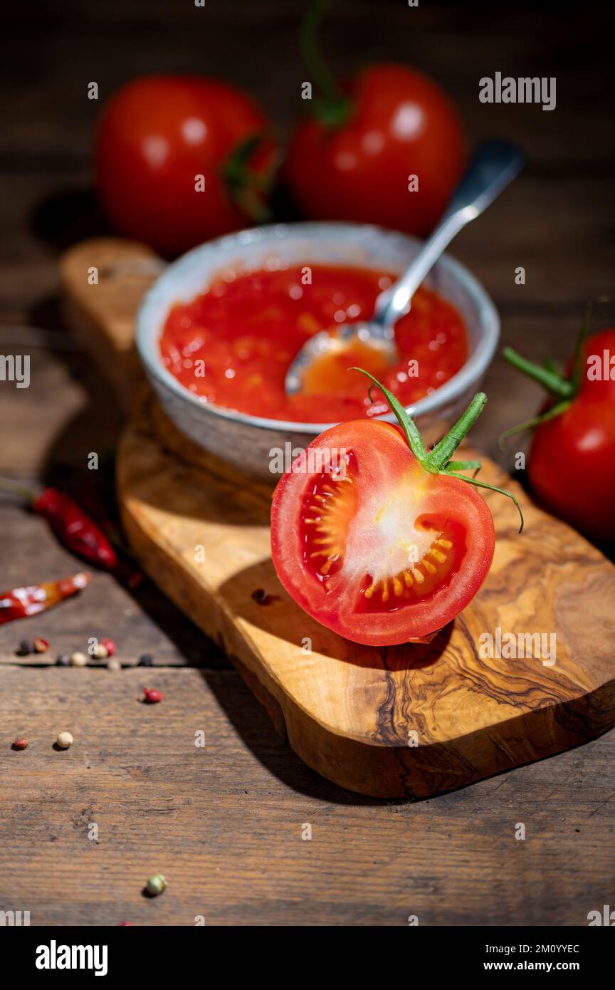 Strained tomatoes in small bowls on rustic cutting board Stock Photo ...