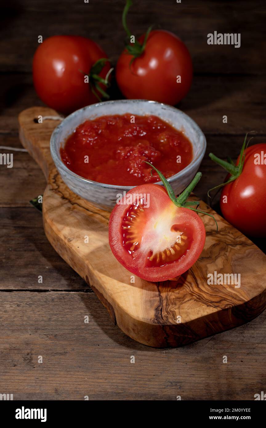 Strained tomatoes in small bowls on rustic cutting board Stock Photo ...
