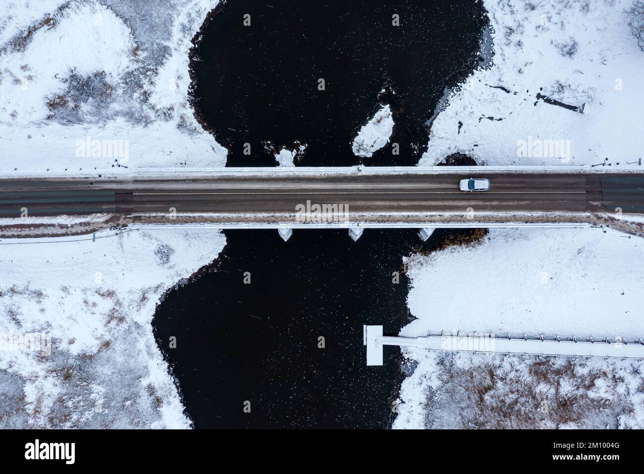 Old stone bridge over the river on a snowy winter day, top down view ...