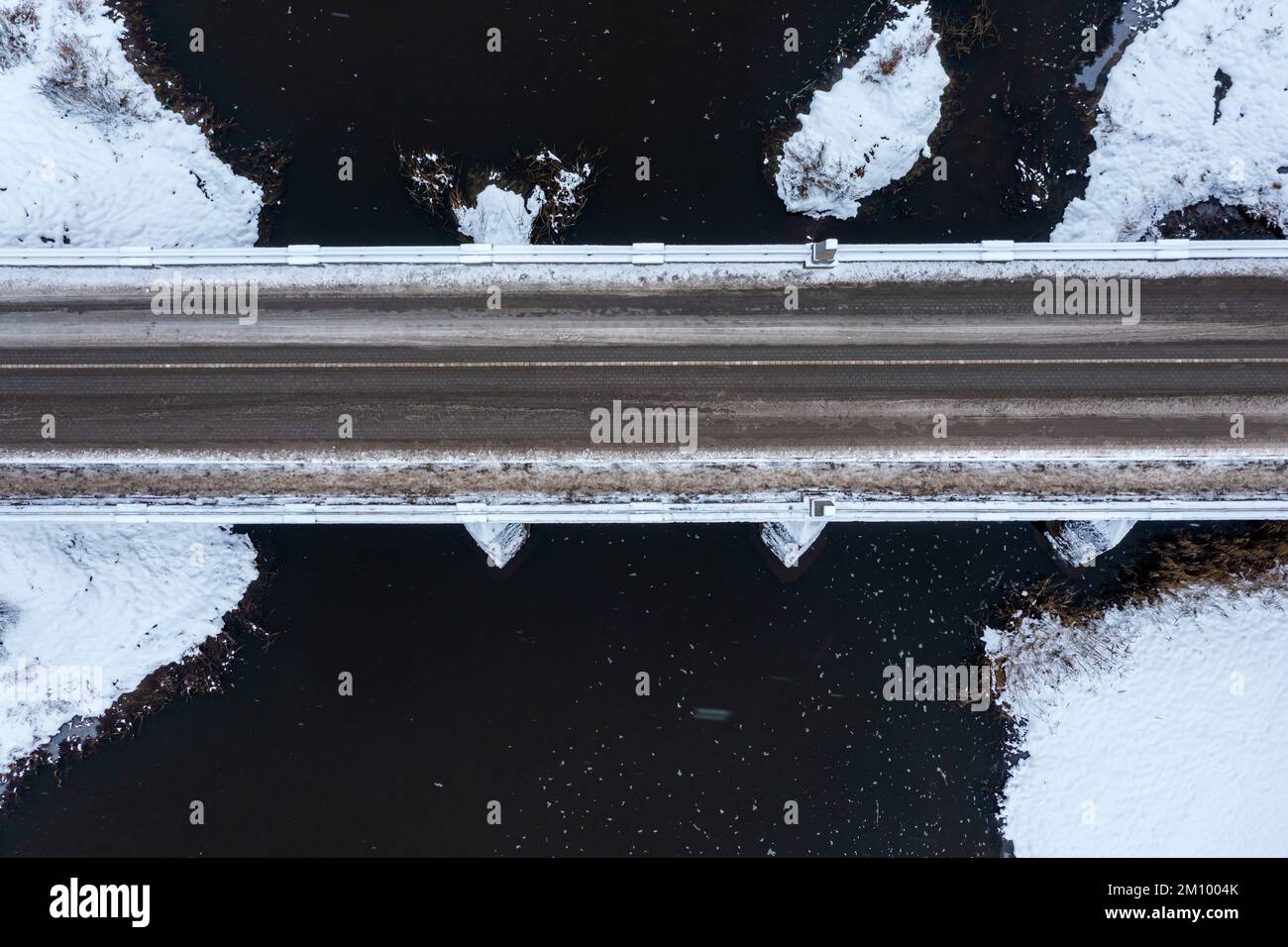 Old stone bridge over the river on a snowy winter day, top down view ...