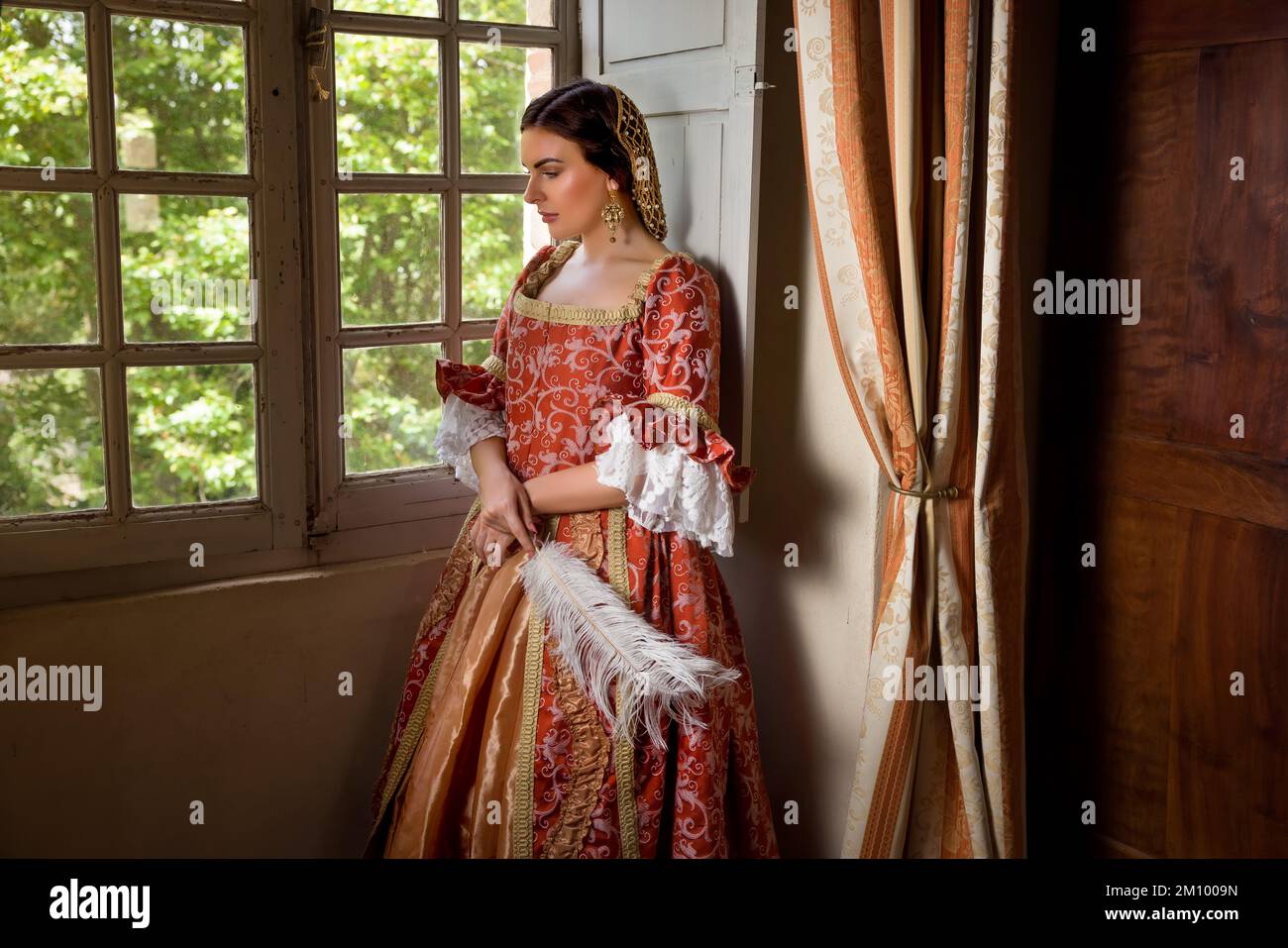 Woman wearing authentic Renaissance costome and headdress standing at ...