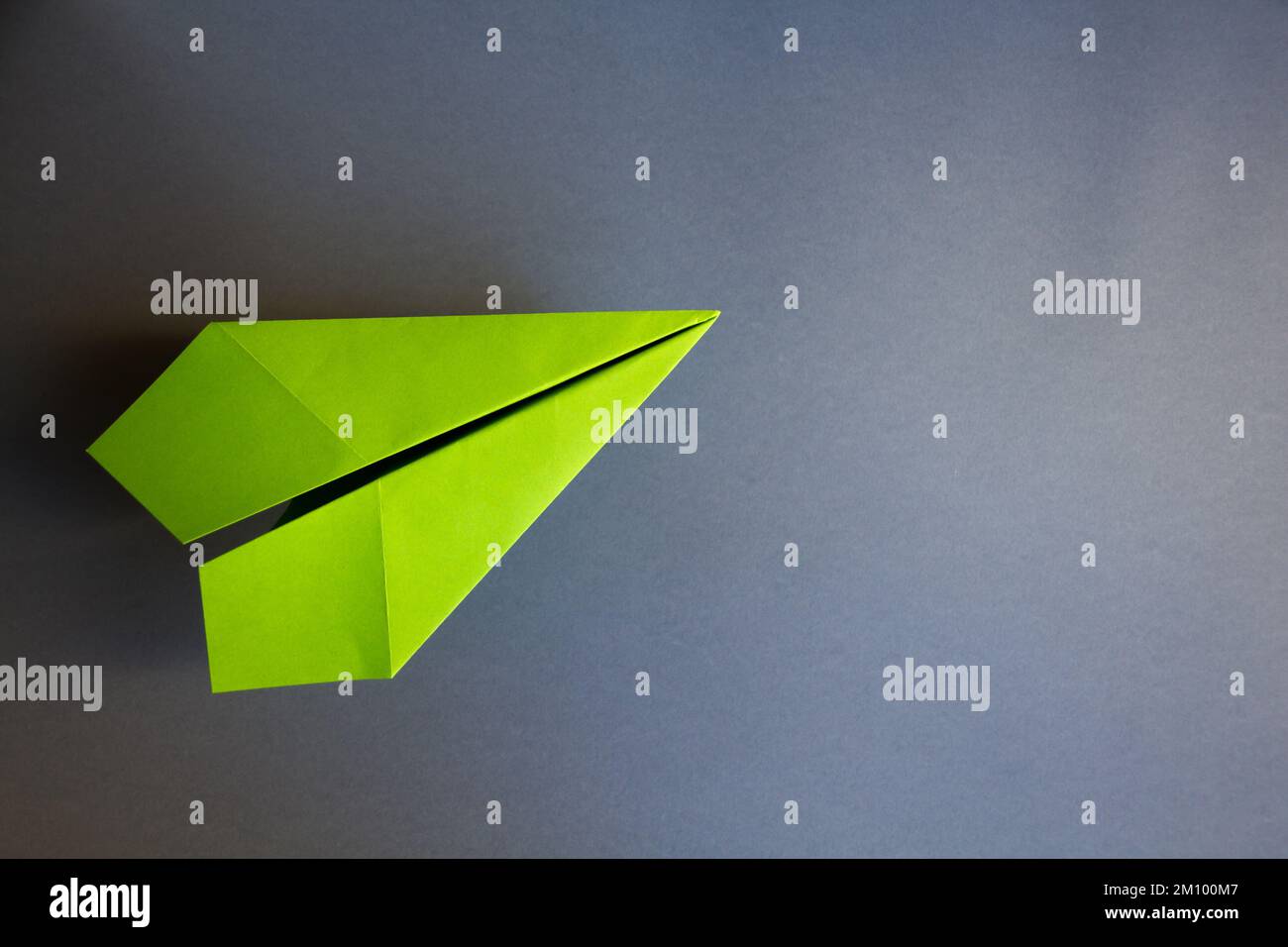 Green paper plane origami isolated on a blank grey background Stock ...