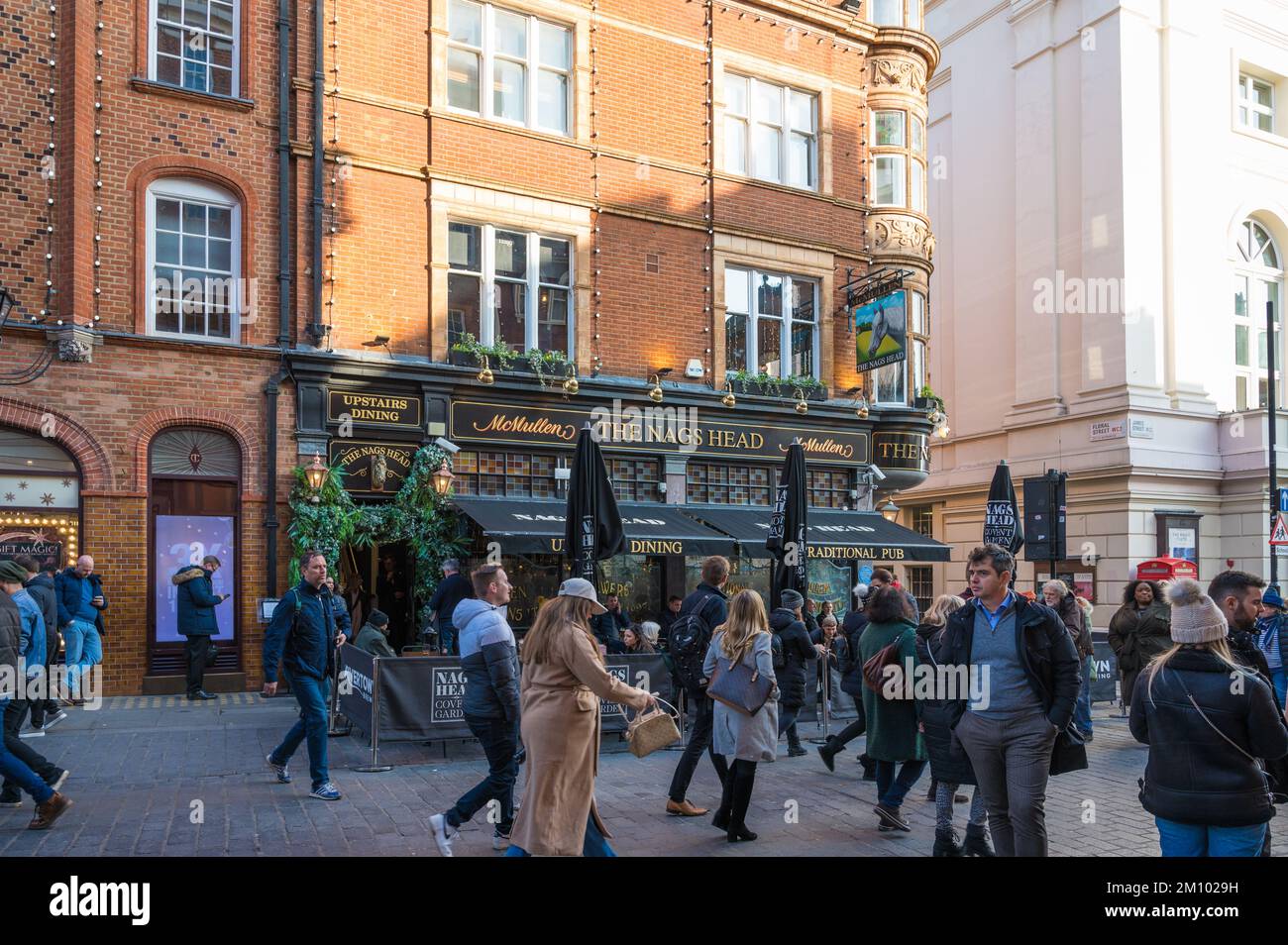 Covent Garden. People shopping pass by the Nags Head pub on James ...