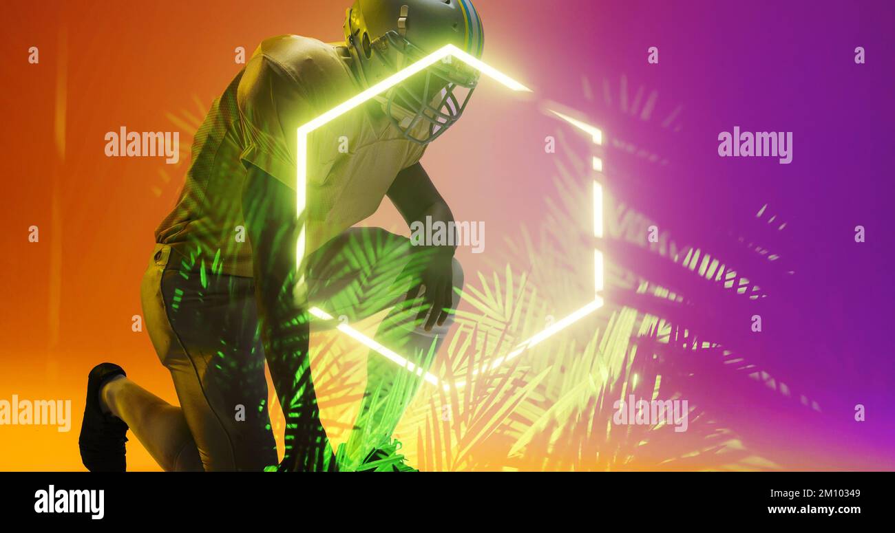American football player with ball kneeling by illuminated hexagon ...