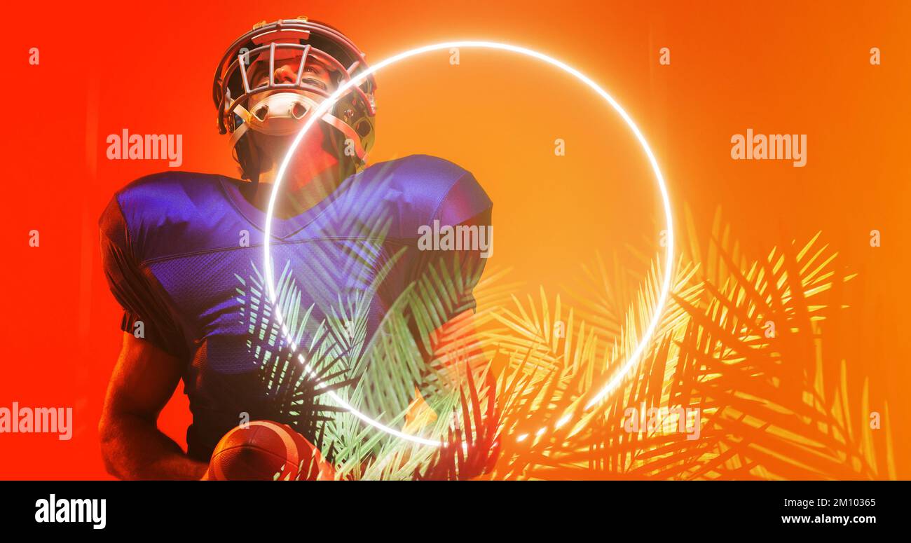 American football player wearing helmet and holding ball standing by ...