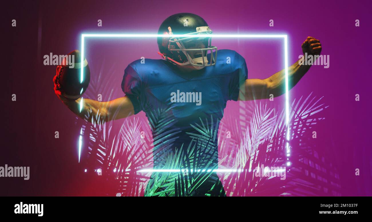 American football player raising arms while standing by illuminated ...