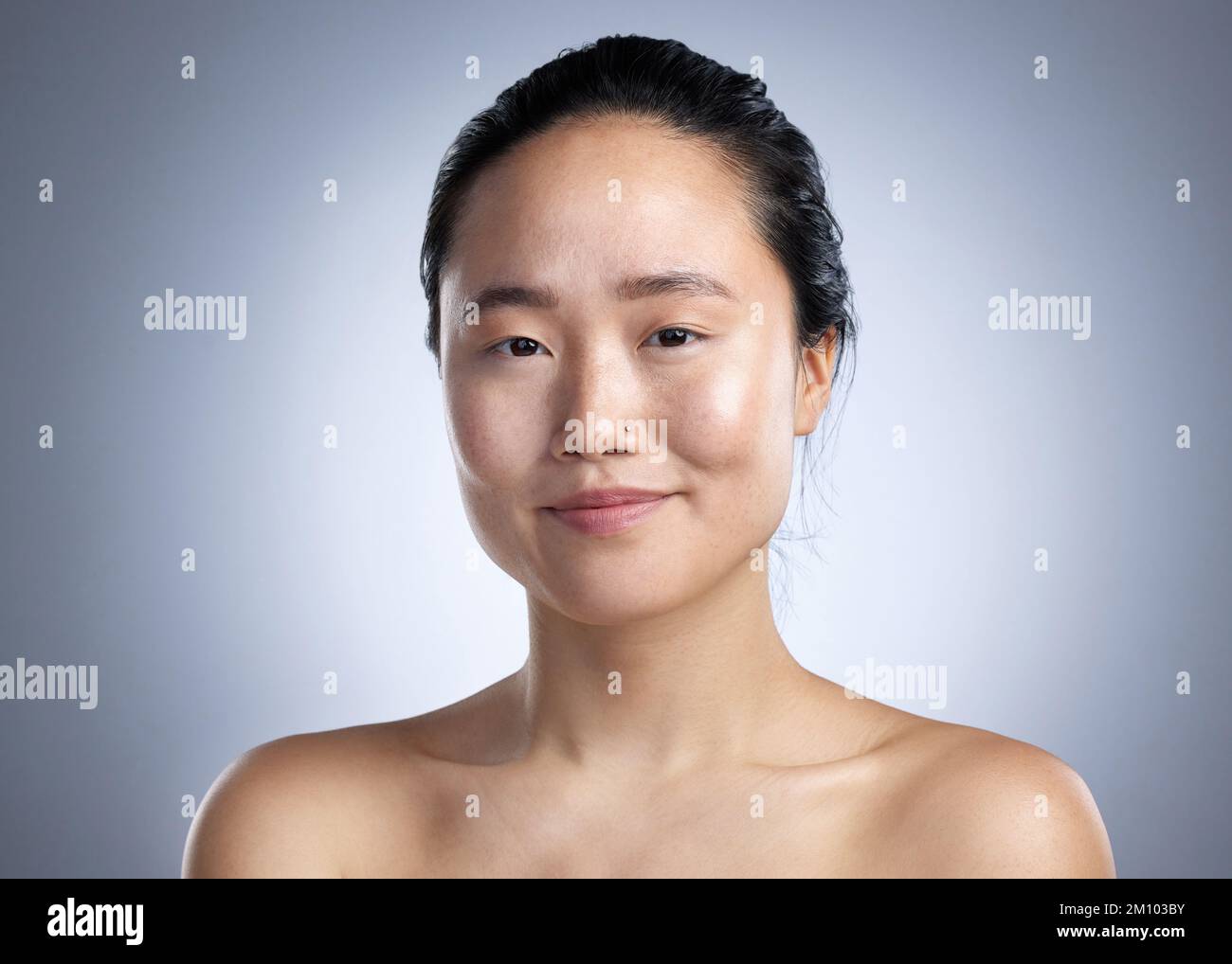 Feeling refreshed. a young woman standing against a grey background ...