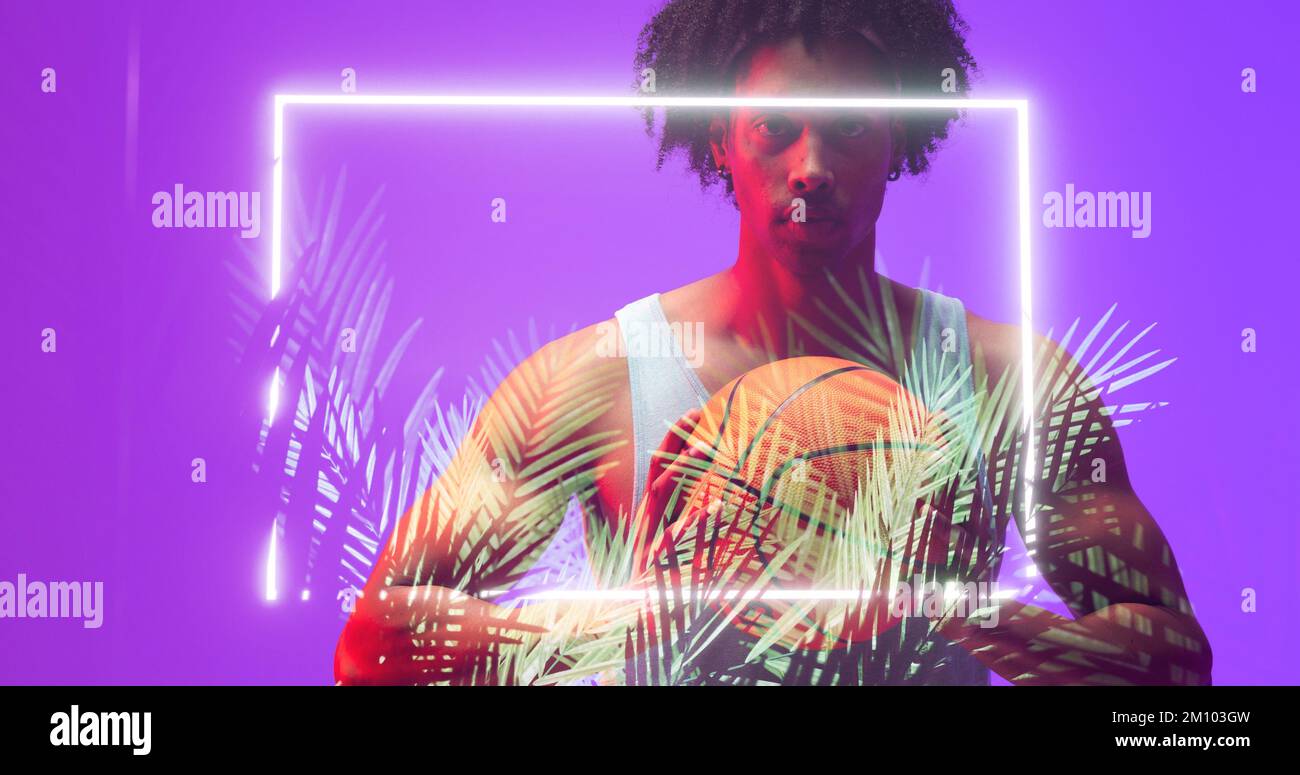 Portrait of biracial player with afro hair holding basketball by ...