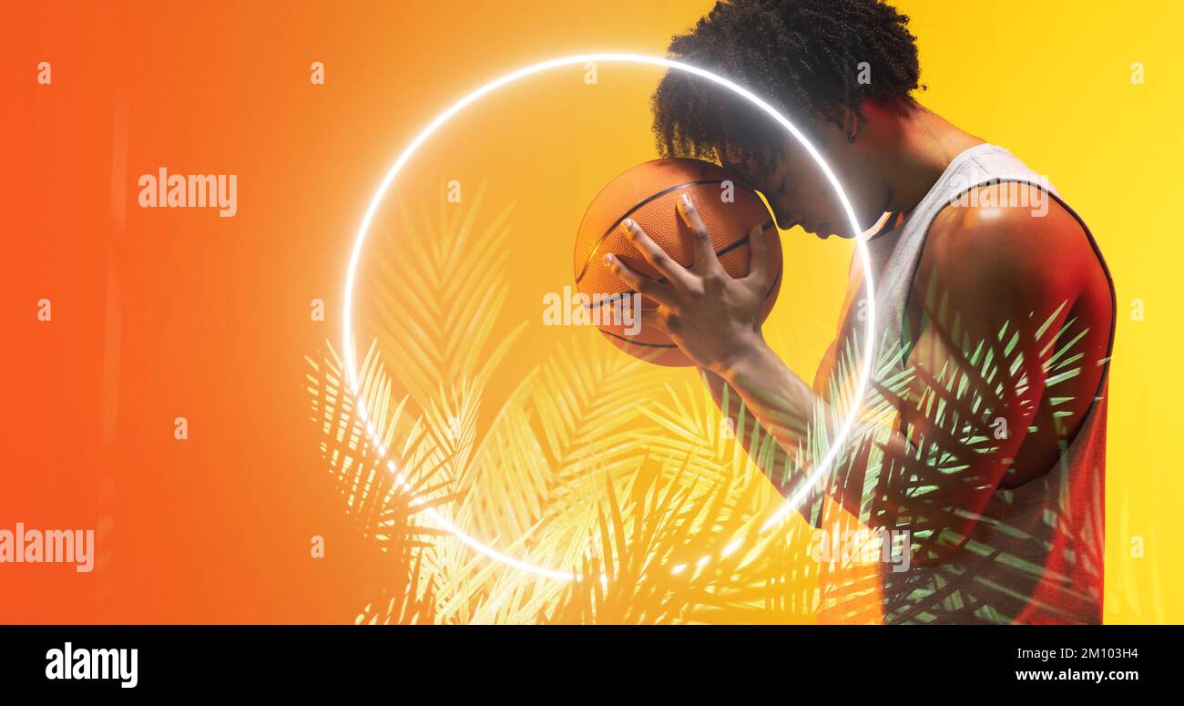 Side view of biracial basketball player with afro hair holding ball on ...