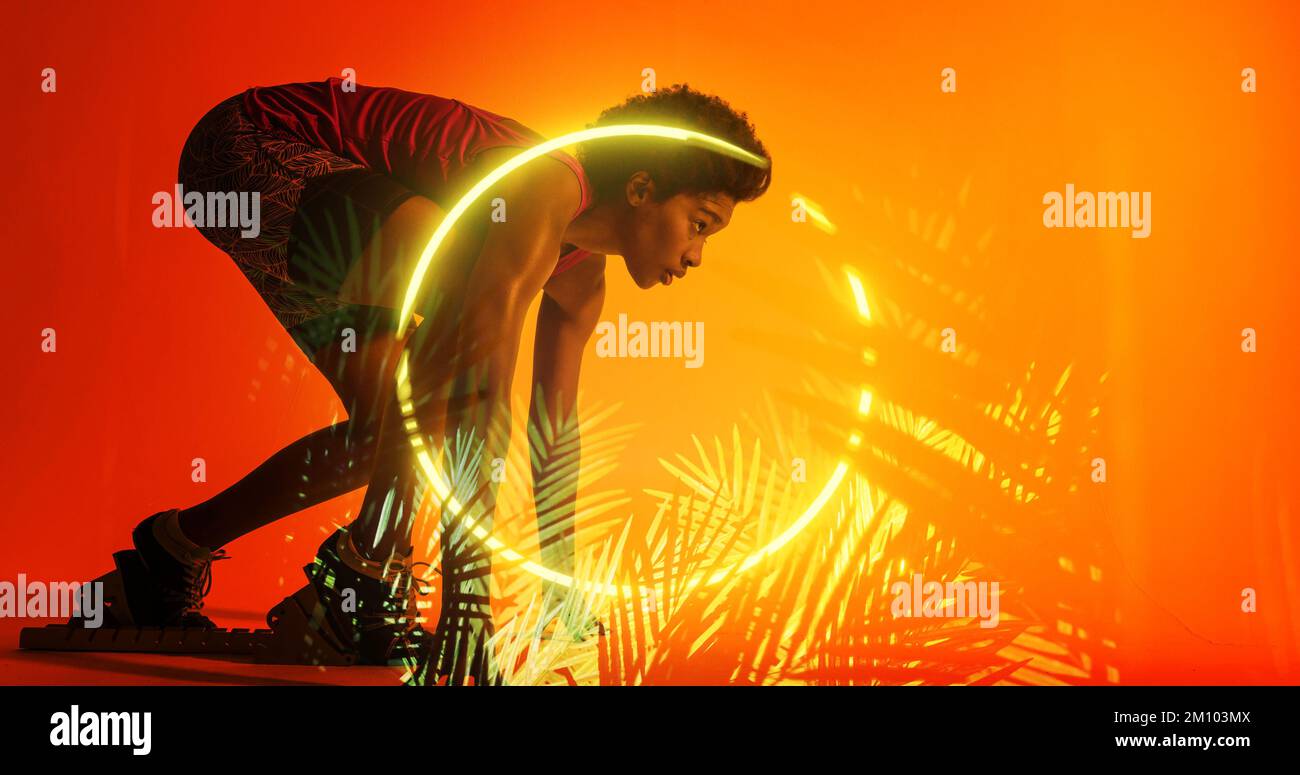 Side view of biracial female athlete at starting position by ...