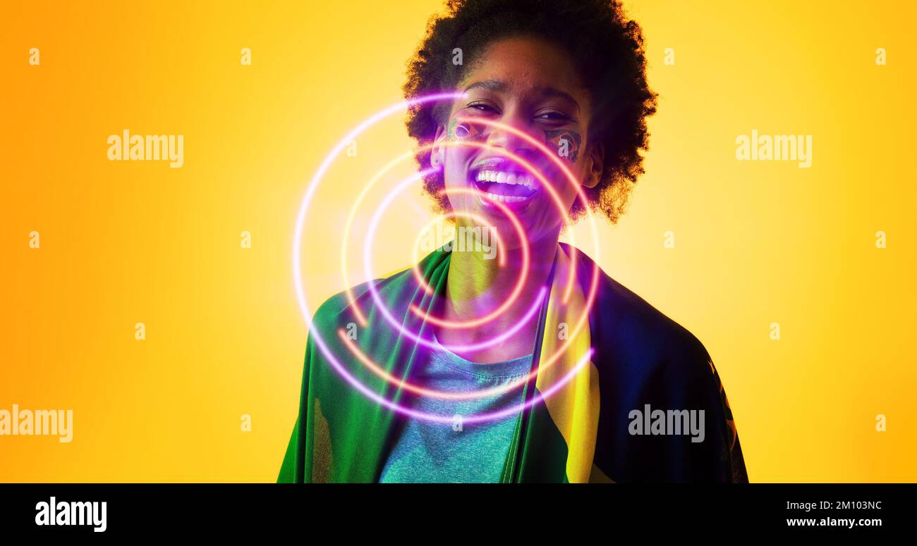 Cheerful biracial female soccer player with brazilian flag laughing ...