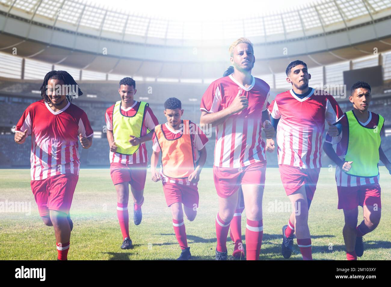 Team of multiracial male soccer players in sports clothing running in ...