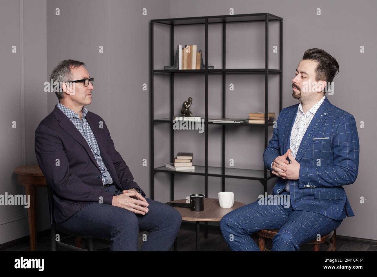Mature businessman discuss information with a younger colleague in ...