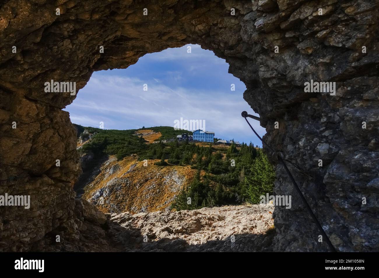 rocky round passage on a hiking path with view to a house in austria ...