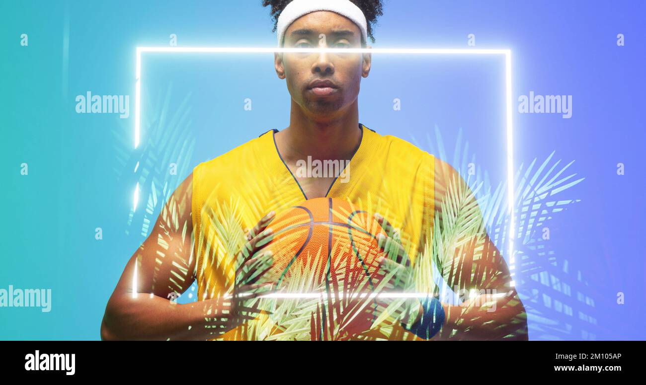Portrait of biracial basketball player holding ball in front of ...
