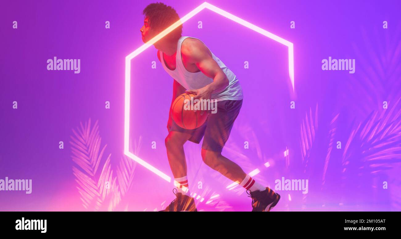 Biracial basketball player dribbling ball by illuminated hexagon and ...