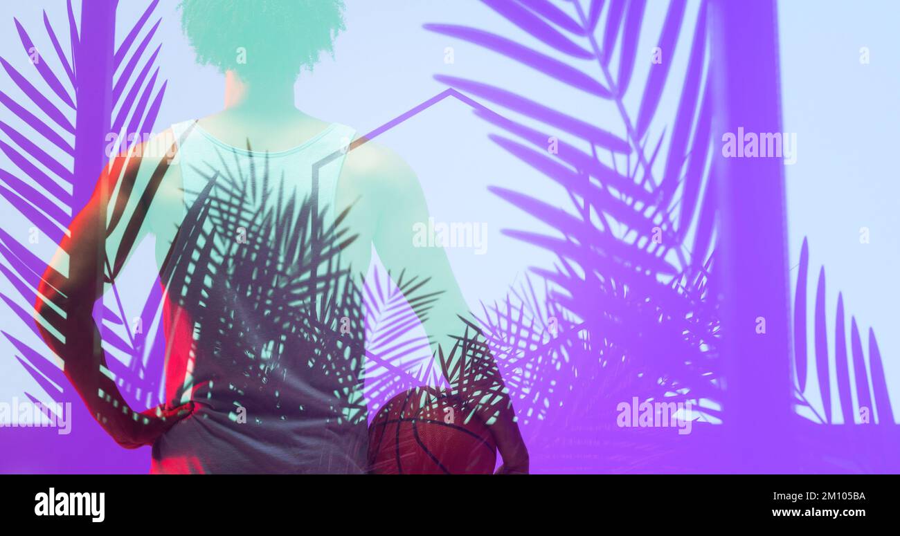 Rear view of biracial basketball player with ball standing over ...