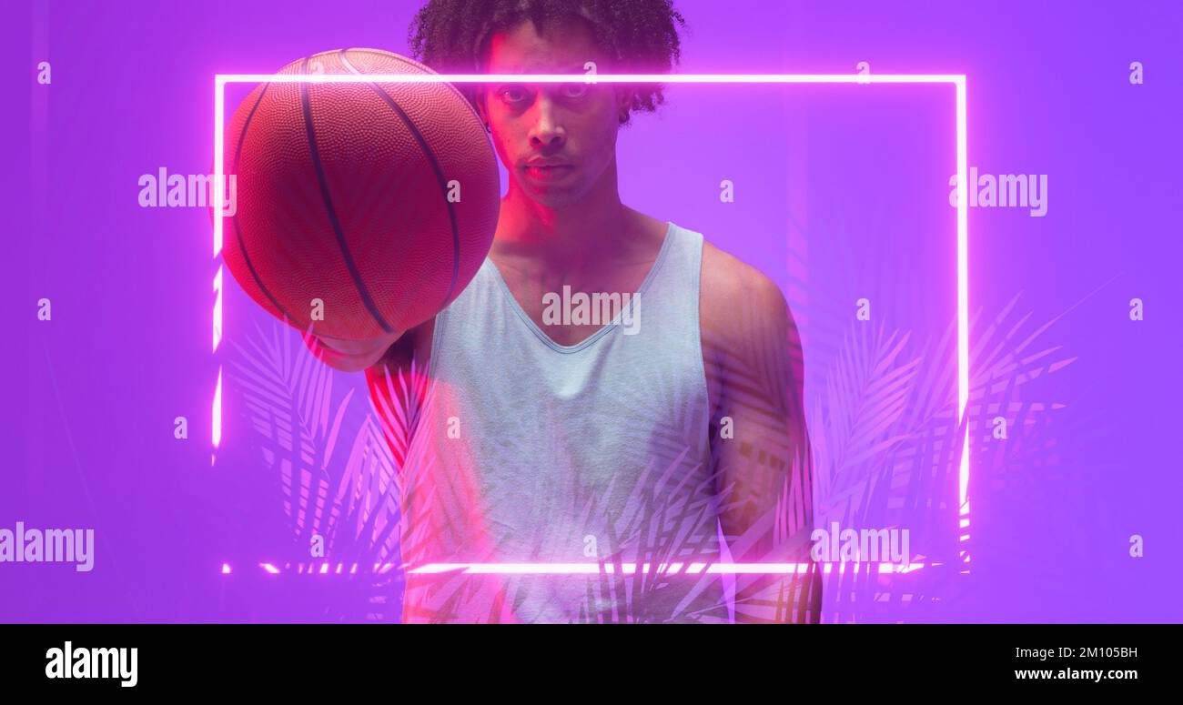 Portrait of biracial player with afro hair holding basketball by ...