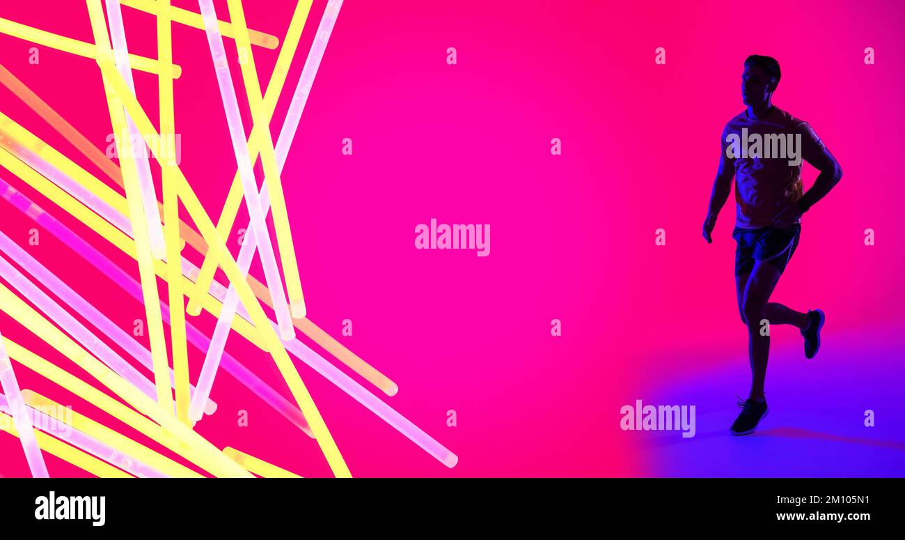 Caucasian young sportsman with colorful neon design running over pink ...