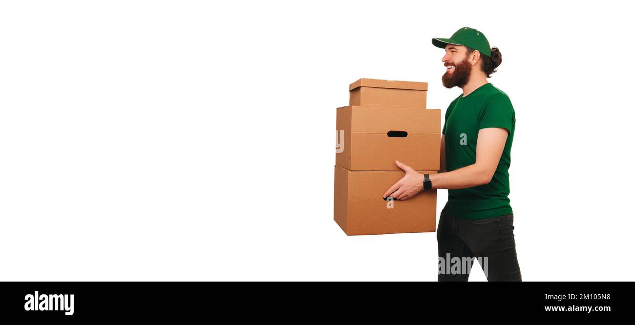 Side view studio shot of a powerful delivery man holding up some boxes ...