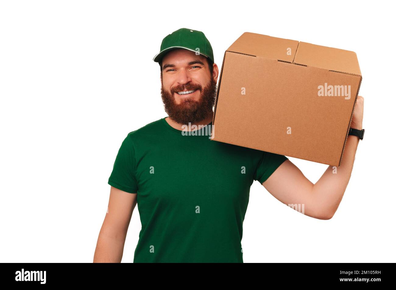 Strong delivery man wearing green uniform holds a carton box over his ...