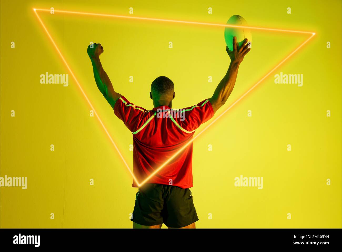 Triangle neon over african american rugby player holding ball with arms ...