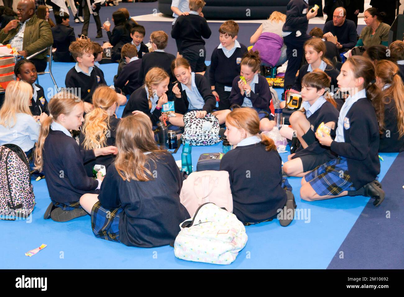 Schoolgirls taking time out to have their lunch during a very busy ...