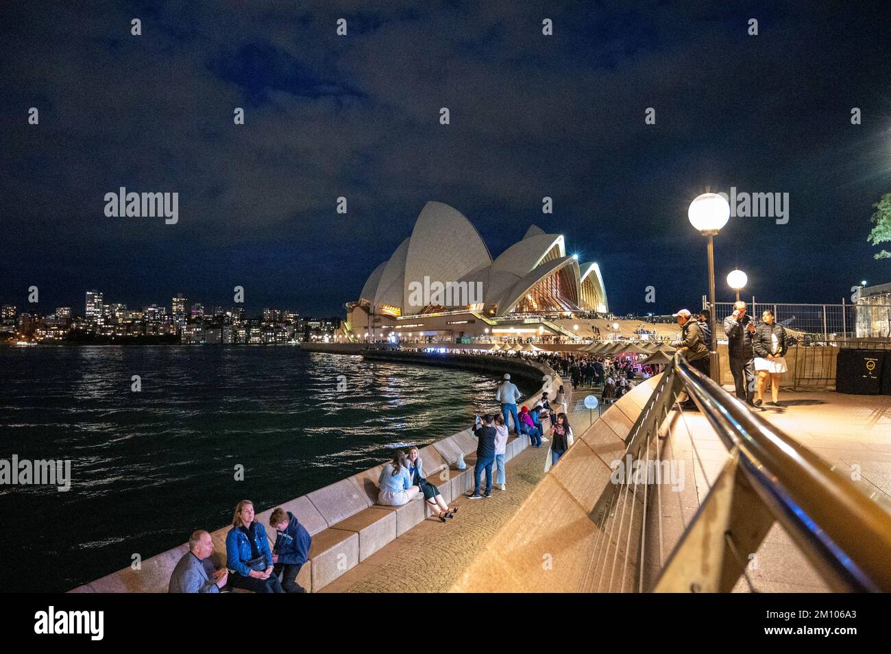 Sydney Opera House at Night with people on waterfront Stock Photo - Alamy