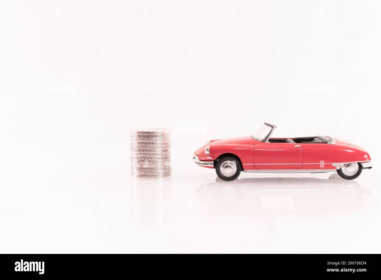 Red miniature sports car with coins Stock Photo - Alamy