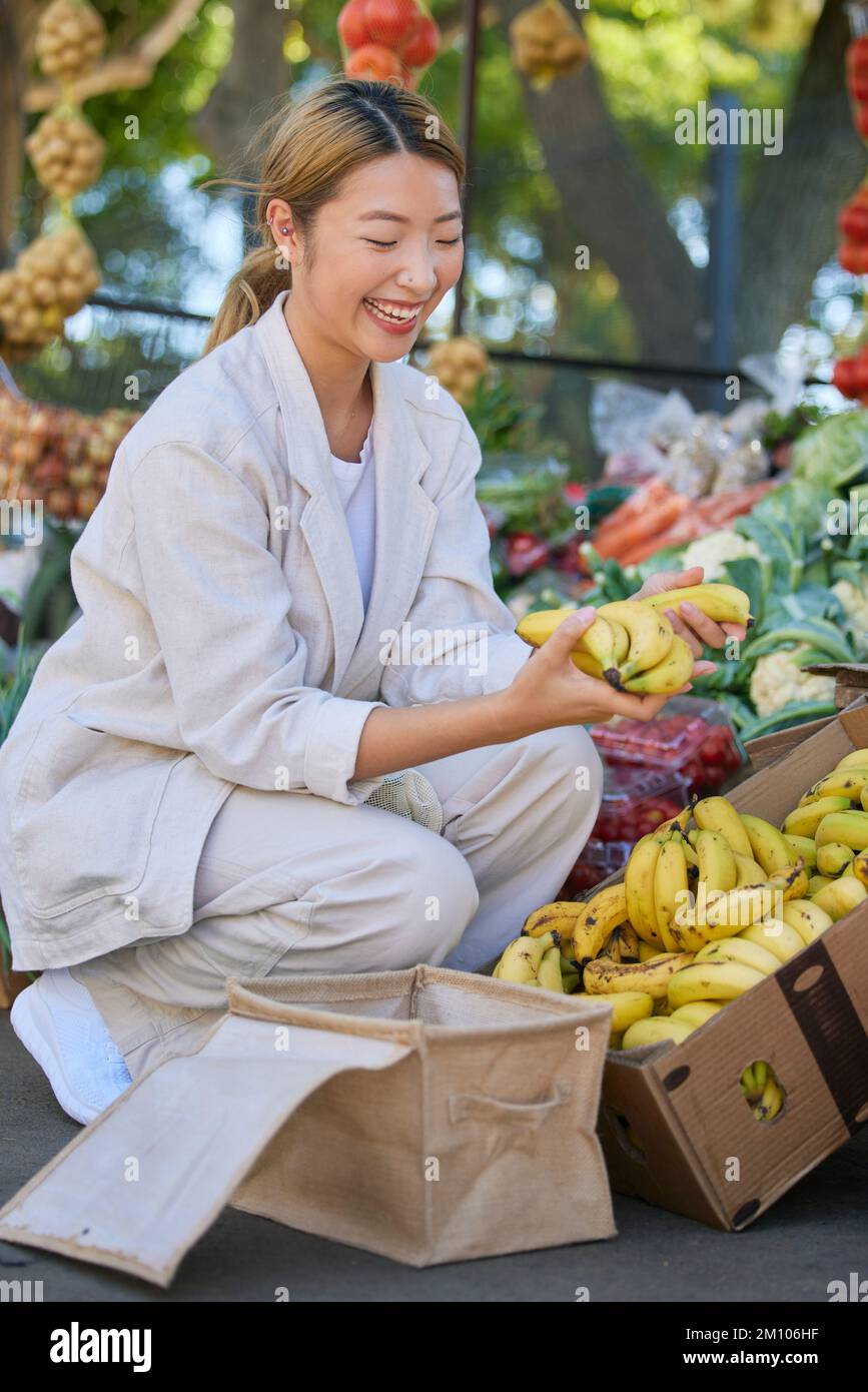 Bananas, shopping and Asian woman at outdoor market buying delicious ...